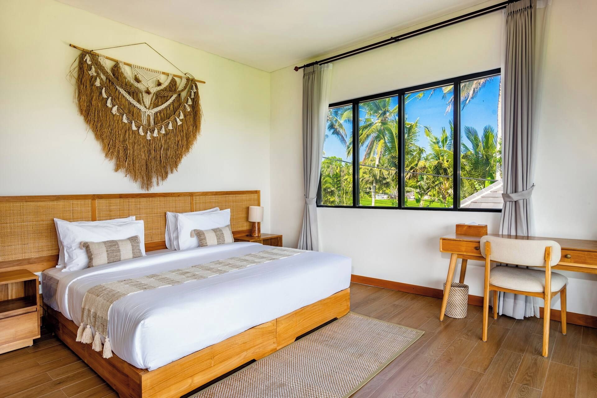 Um quarto com cama, mesas de cabeceira, escrivaninha e cadeira.