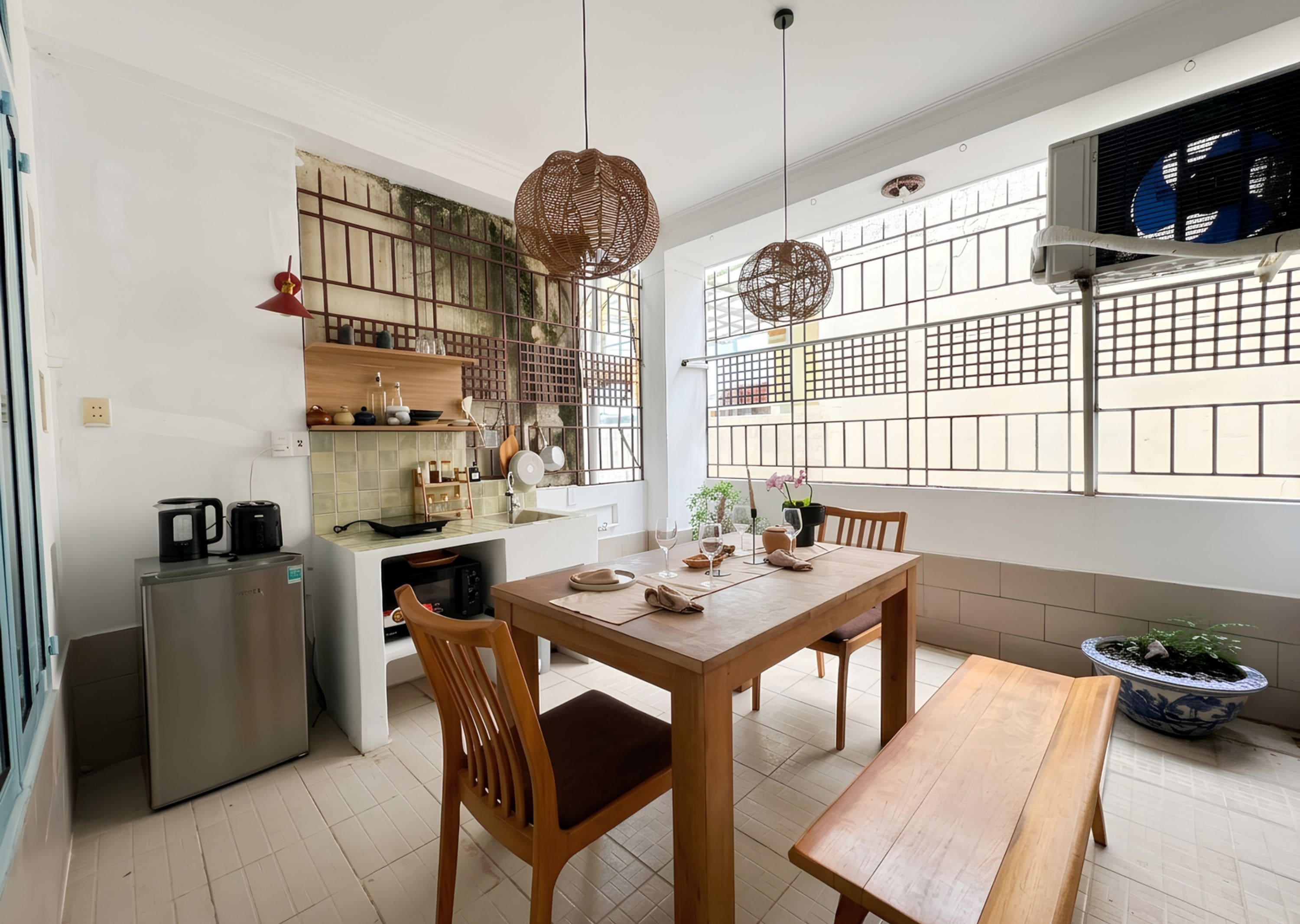 Cozinha moderna com área de refeições, incluindo geladeira, fogão e mesa de madeira com cadeiras.