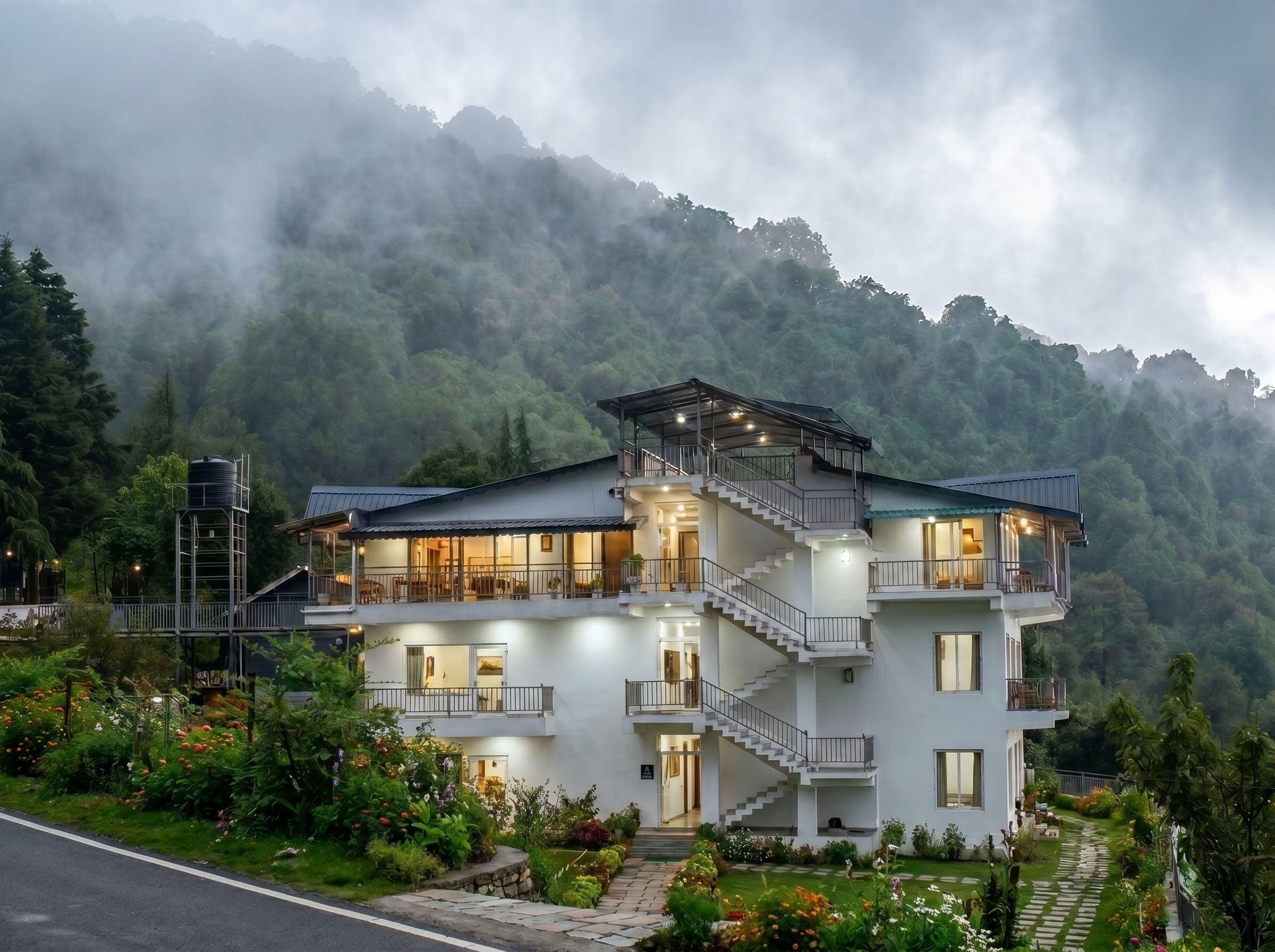 Um hotel com vários andares, varandas, uma escadaria e um jardim.