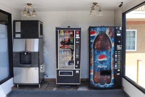 Quarto com dispensador de água, máquina de bebidas e máquina de Pepsi.