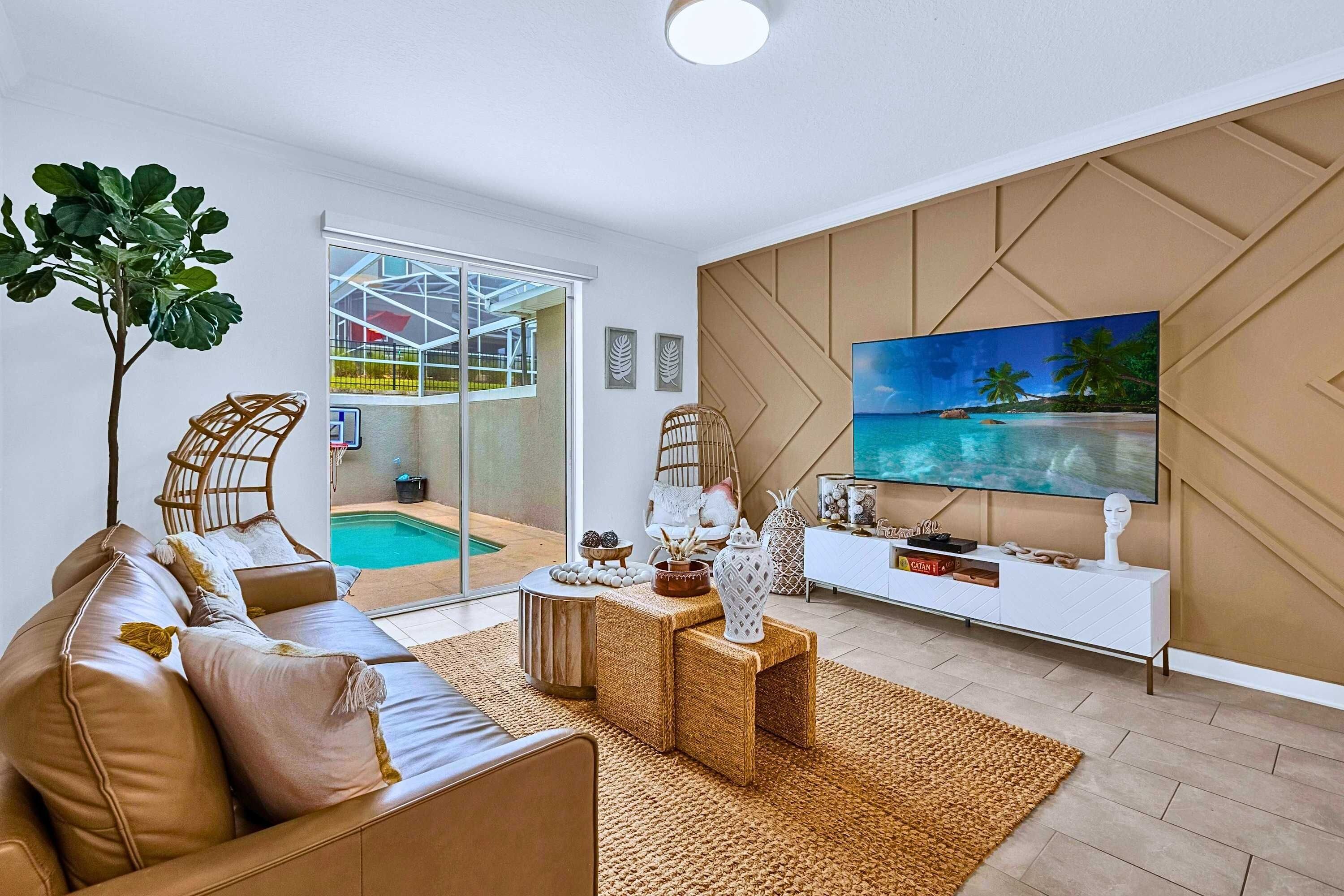 Uma sala de estar moderna com sofá, mesa de centro e televisão na parede.