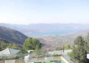 Terraço com vista para um vale e um corpo d'água.
