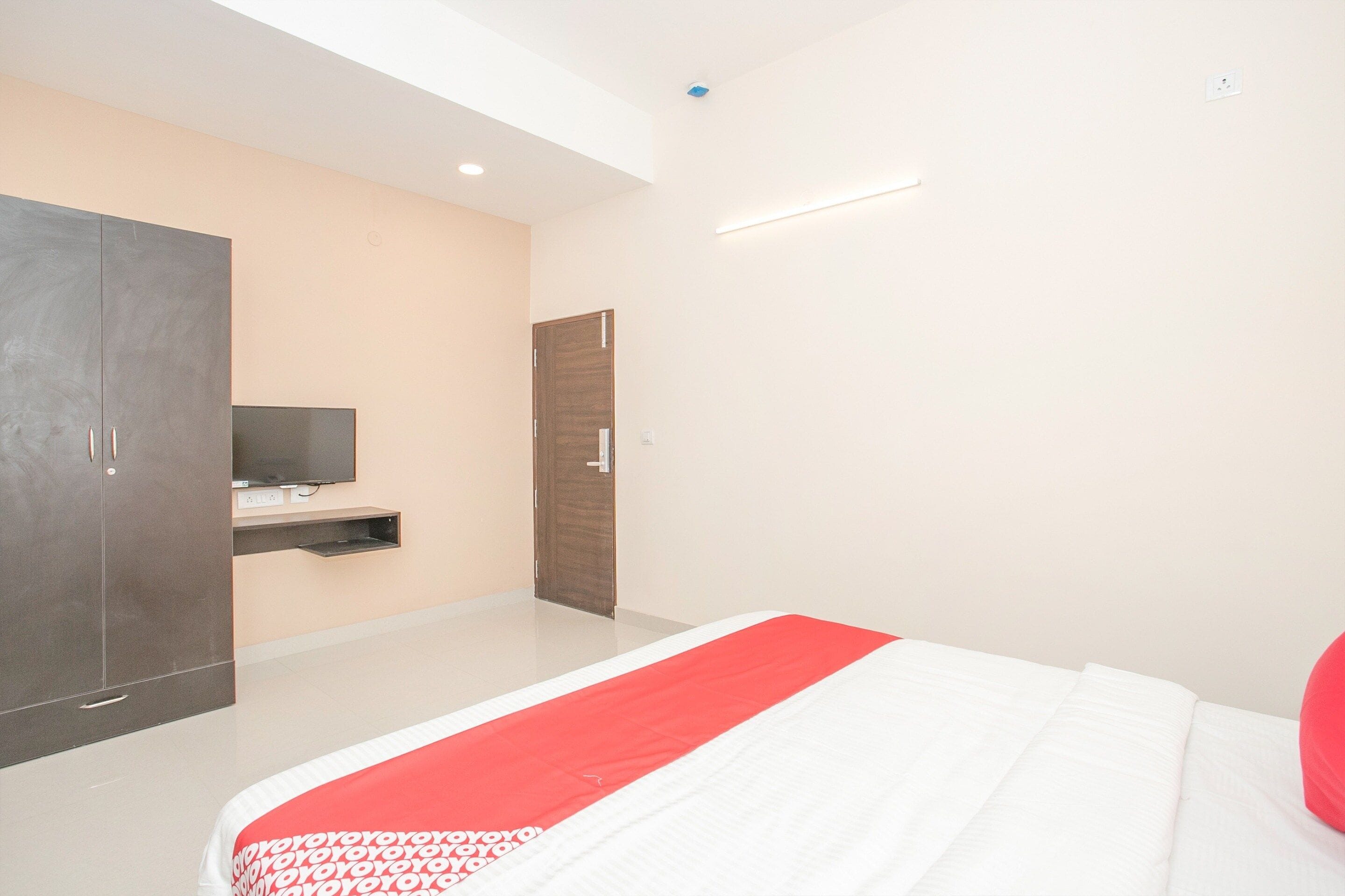 Quarto moderno com cama grande, guarda-roupa, espelho e porta.
