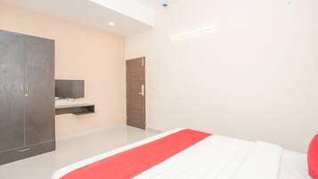 Quarto moderno com cama grande, guarda-roupa, espelho e porta.