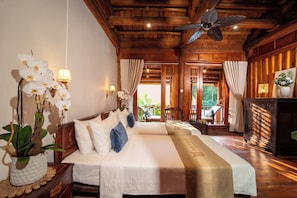 Quarto de hotel com duas camas, teto de madeira e vista para o exterior.