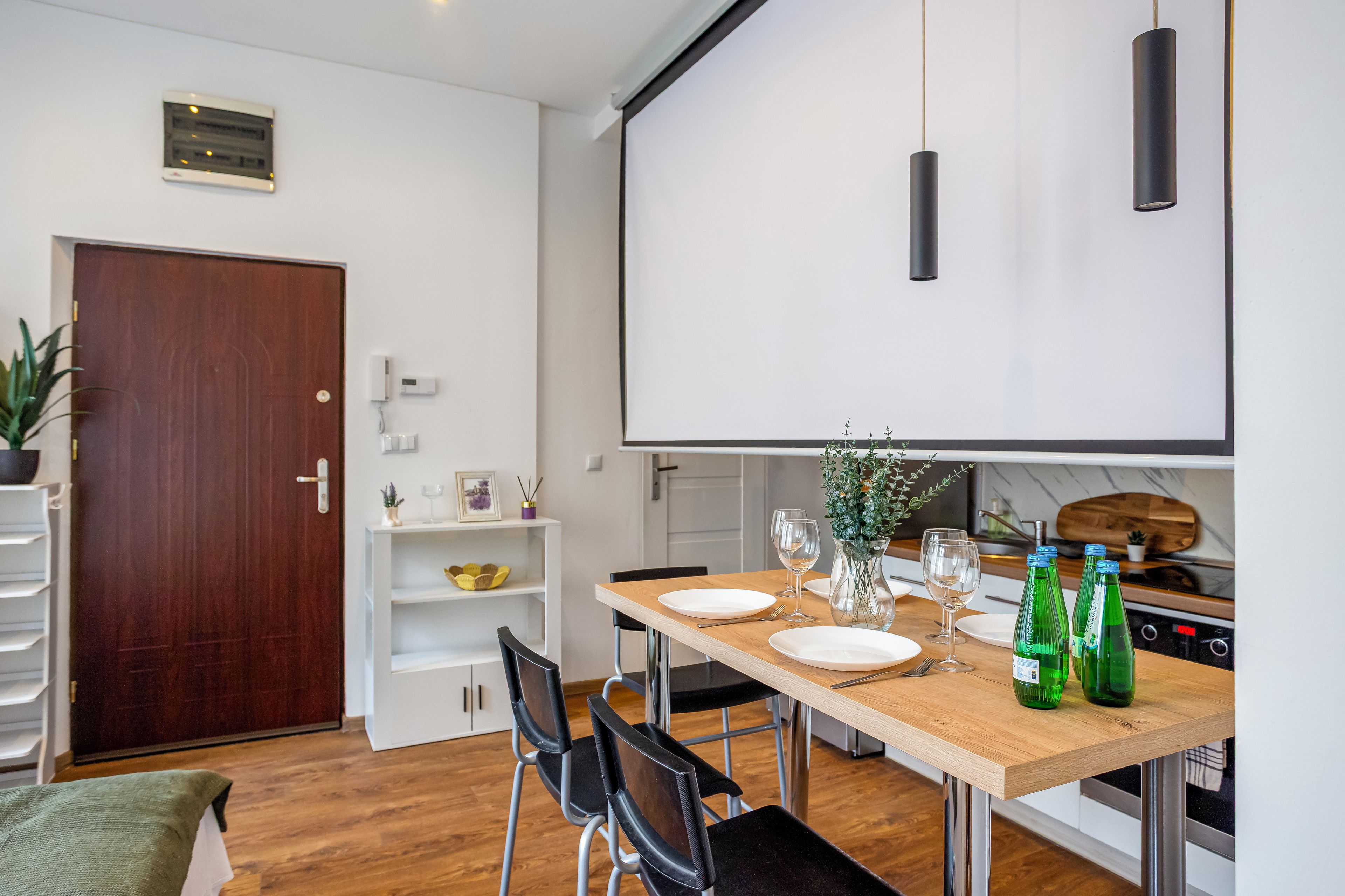 Cozinha moderna com mesa de jantar de madeira, cadeiras e forno embutido.