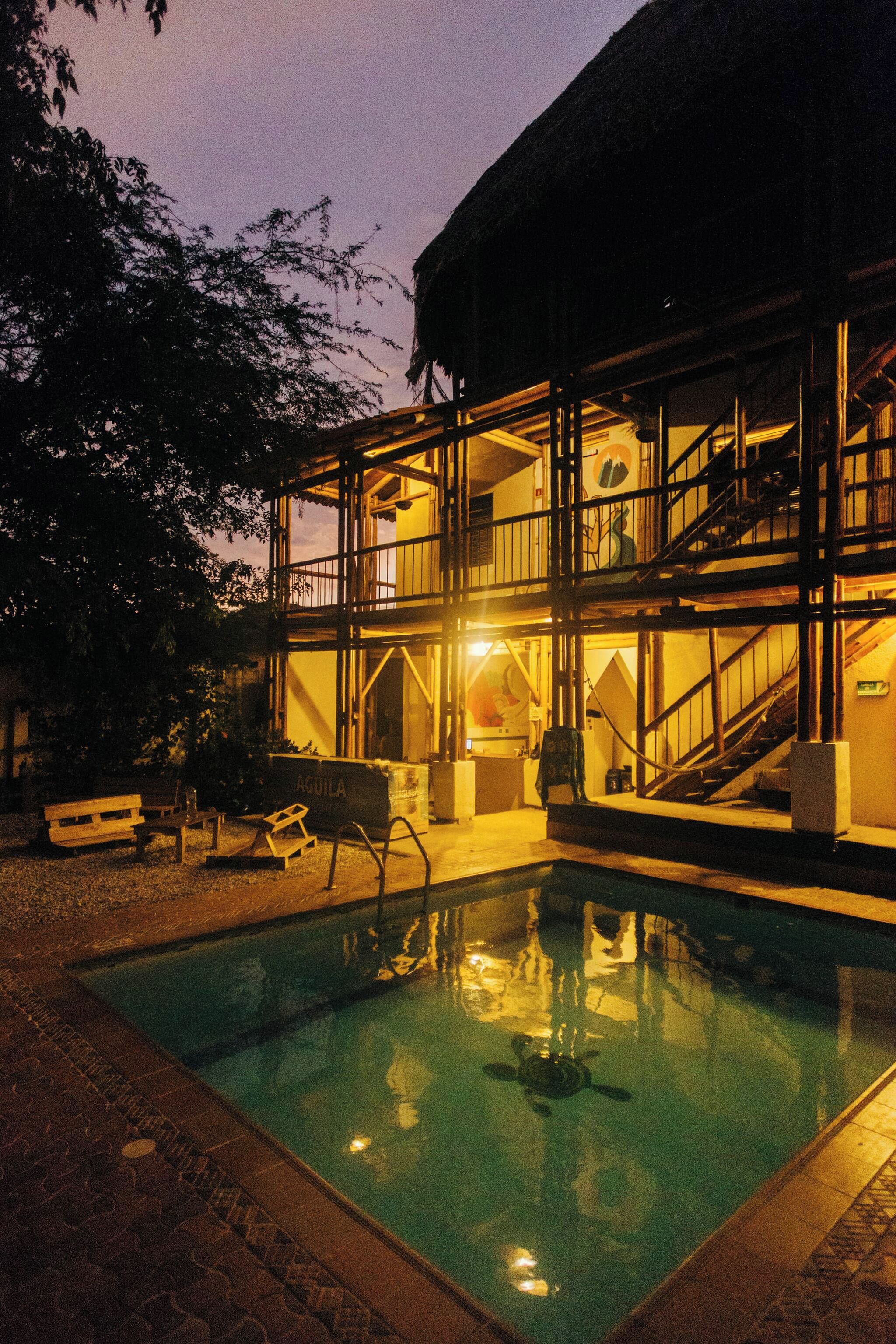 Um edifício de dois andares com piscina em frente.