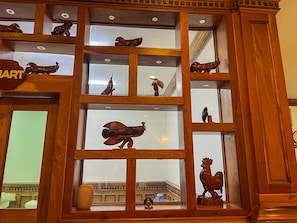 Uma vitrine de madeira com várias prateleiras, cada uma exibindo diversas esculturas.