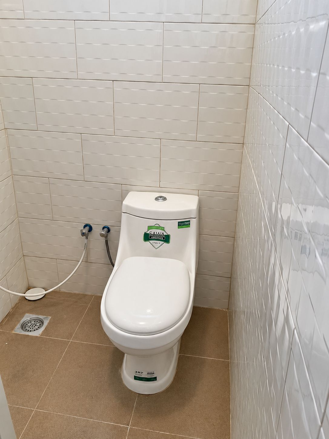Sanitário branco com identificação 'Cawa', bidê fixado na parede e ralo no chão.
