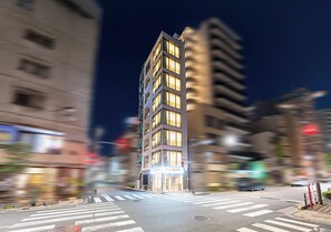 Um hotel com vários andares e design moderno, destacando uma entrada imponente e janelas iluminadas.