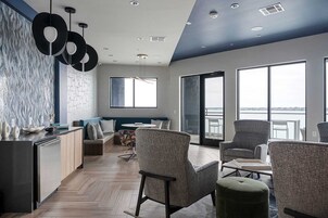 Interior moderno com cozinha, área de estar e janelas amplas com vista.