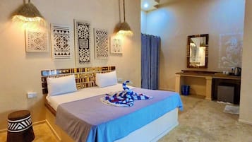 Quarto de hotel com cama, mesa de cabeceira, espelho e obras de arte nas paredes.
