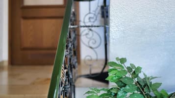 Escadaria com corrimão de metal e um vaso de planta.