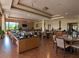Uma área de buffet ampla com diversas estações de serviço, grande variedade de comidas e opções de assentos.