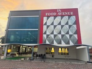 Edifício com uma placa indicando 'FOOD AVENUE' e design moderno, com janelas amplas e fachada estampada.