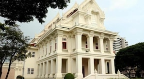 Um edifício grande e branco com várias janelas e uma entrada destacada.