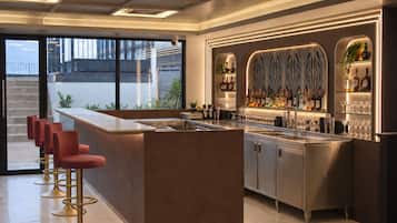 Uma área de bar moderna com ilha central, banquetas e espaço para exibição de vinhos.