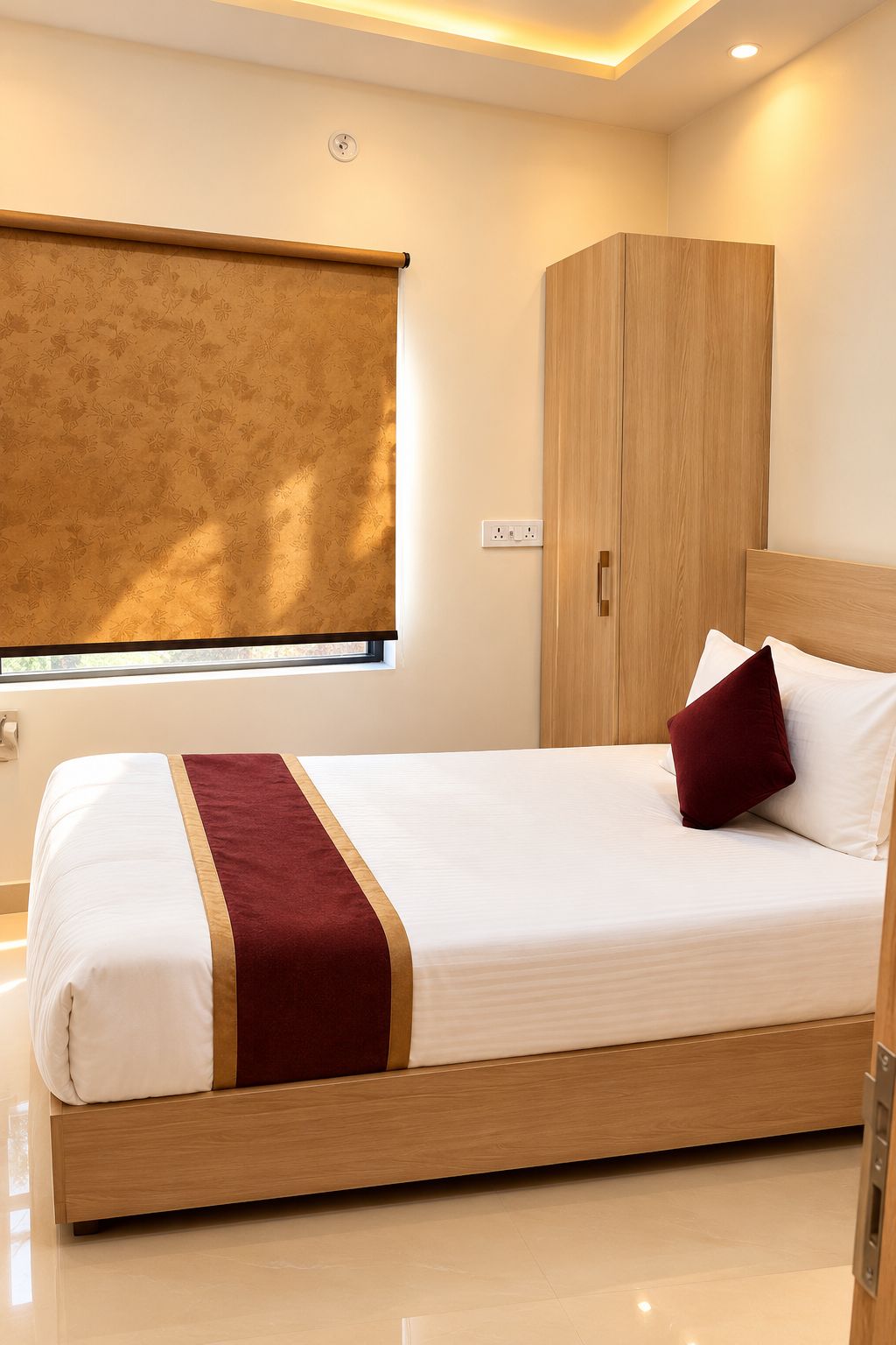 Quarto de hotel com cama, guarda-roupa e janela com cortina.