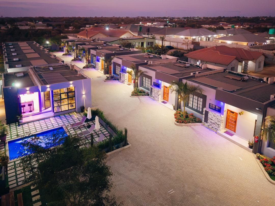 Um complexo de edifícios comerciais com várias unidades, um pátio central e uma piscina.