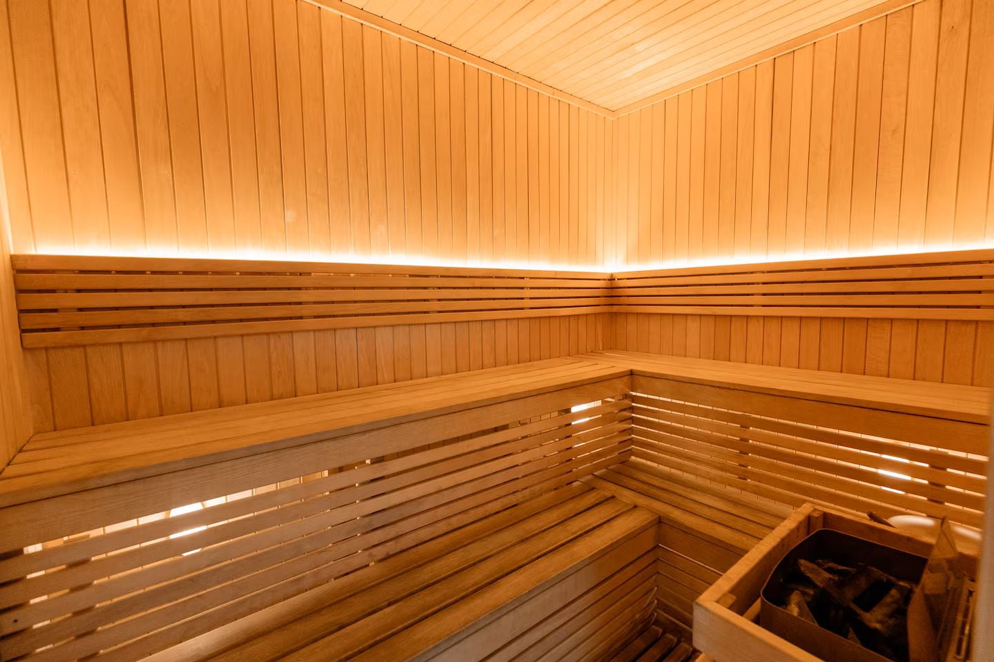 Uma sauna com bancos de madeira e um elemento de aquecimento visível.
