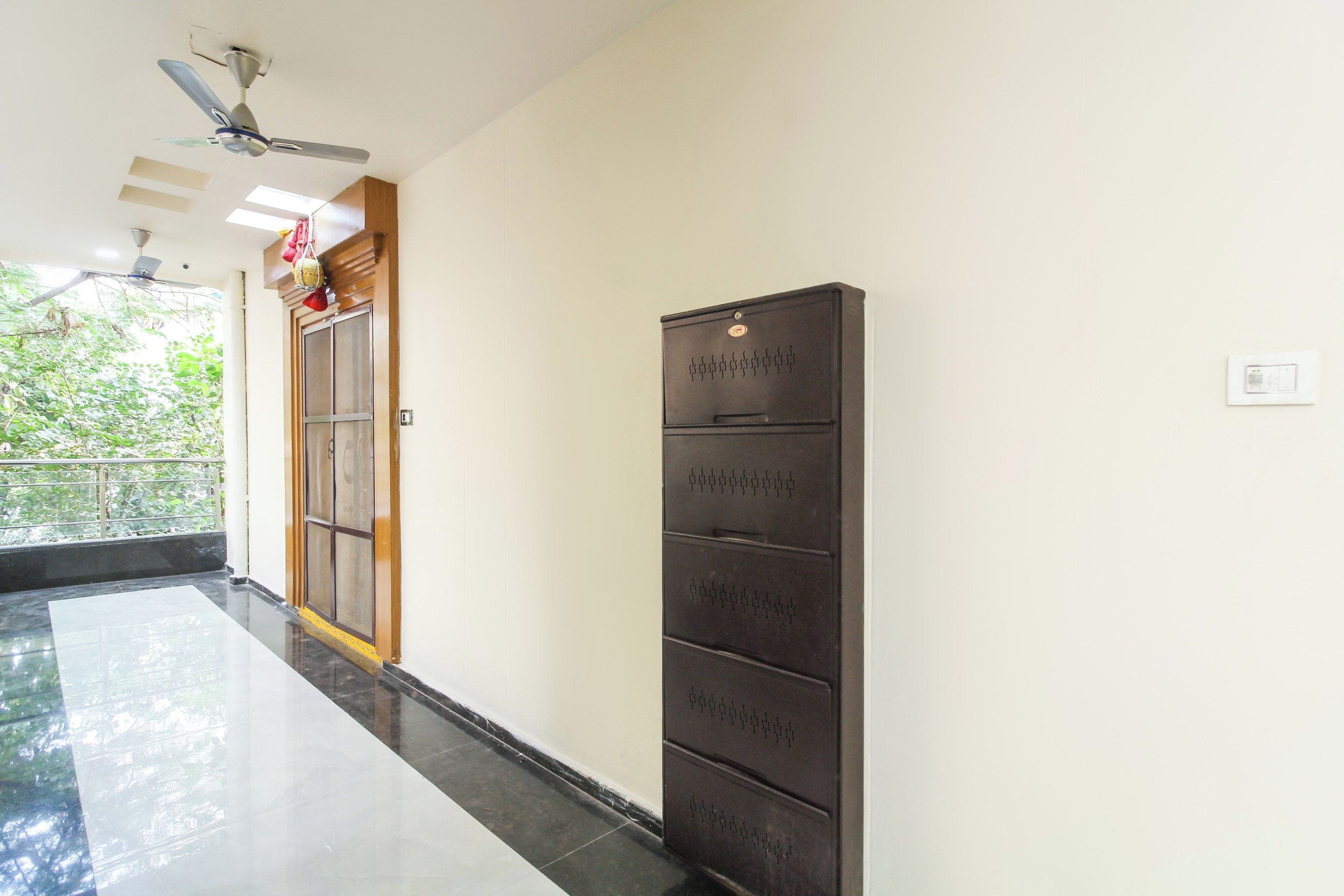 Um corredor com ventilador de teto, porta de madeira e armário de arquivos.