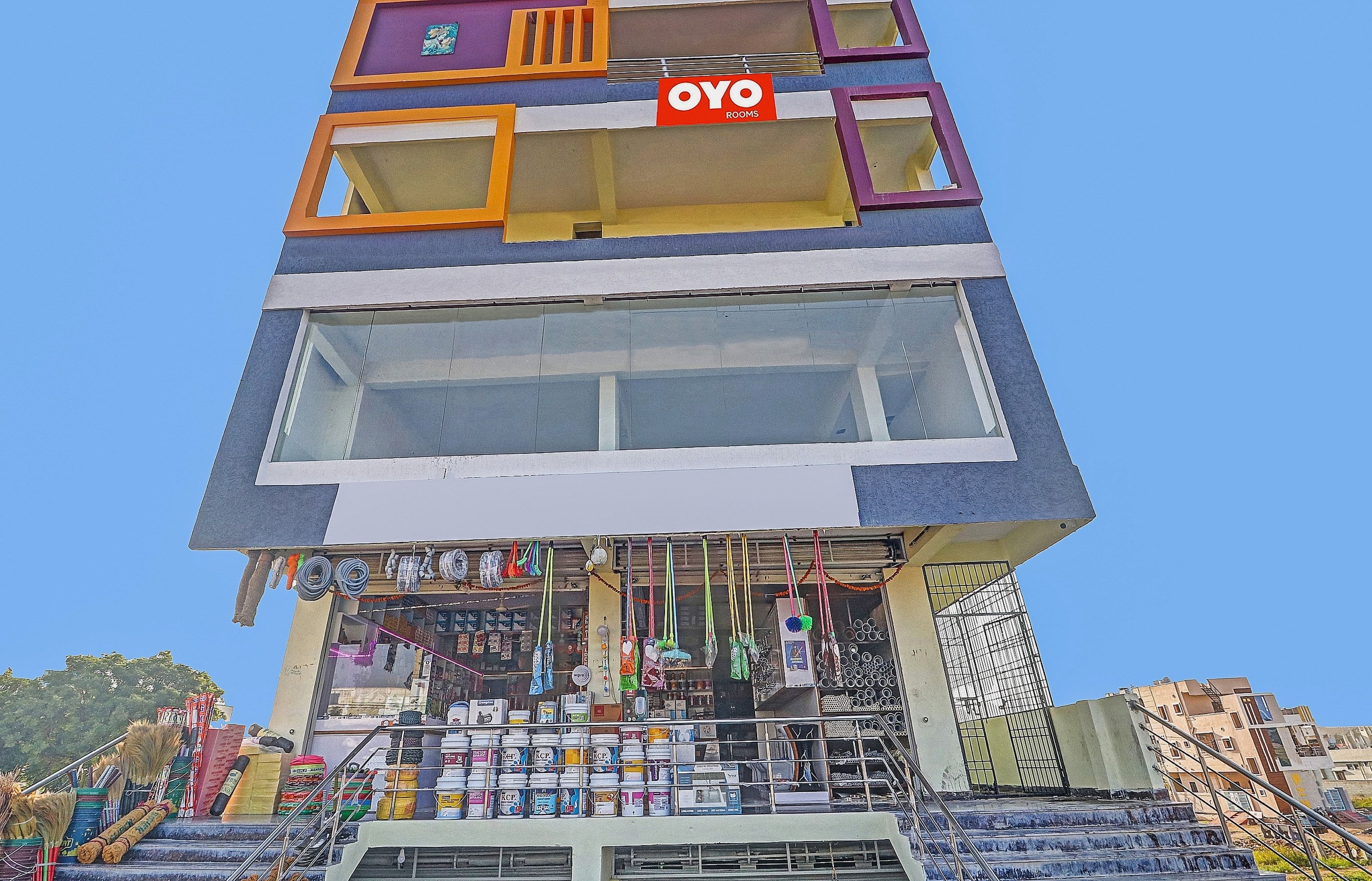 Um edifício com vários andares e placa indicando 'OYO ROOMS', identificando-o como um hotel.