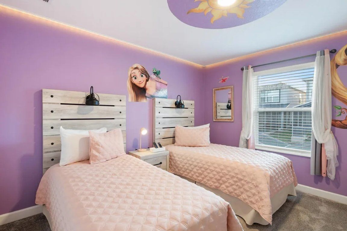 Quarto com duas camas, uma mesa de cabeceira, um espelho e uma janela com cortinas.