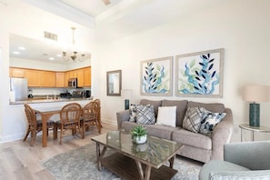 Uma sala de estar moderna com sofá, mesa de centro e área de jantar com cadeiras.
