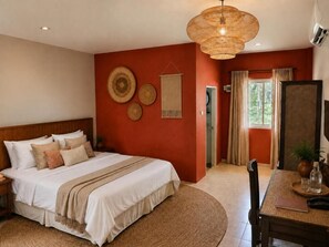 Quarto com cama, mesa de cabeceira e luminária pendente.