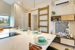 Cozinha moderna com bancada de mármore, escada de madeira e painel de arte com nuvem de palavras.