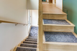 Uma escada de madeira com corrimão e degraus carpetados.
