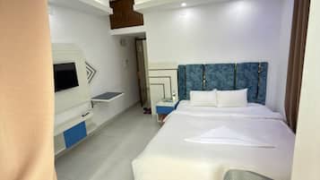 Quarto de hotel moderno com uma cama grande, uma escrivaninha e um ventilador de teto.
