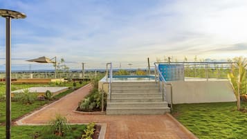 Área da piscina com uma placa detalhando as regras, uma escadaria de acesso e vista da paisagem ao redor.