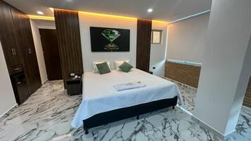 Quarto moderno com piso de mármore, cama com roupa de cama branca e uma obra de arte na parede.