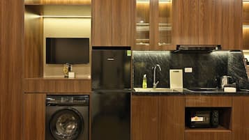 Uma cozinha moderna com máquina de lavar embutida, frigorífico e micro-ondas.
