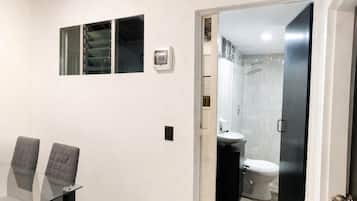Uma casa de banho moderna com cabine de duche em vidro, sanita e lavatório.