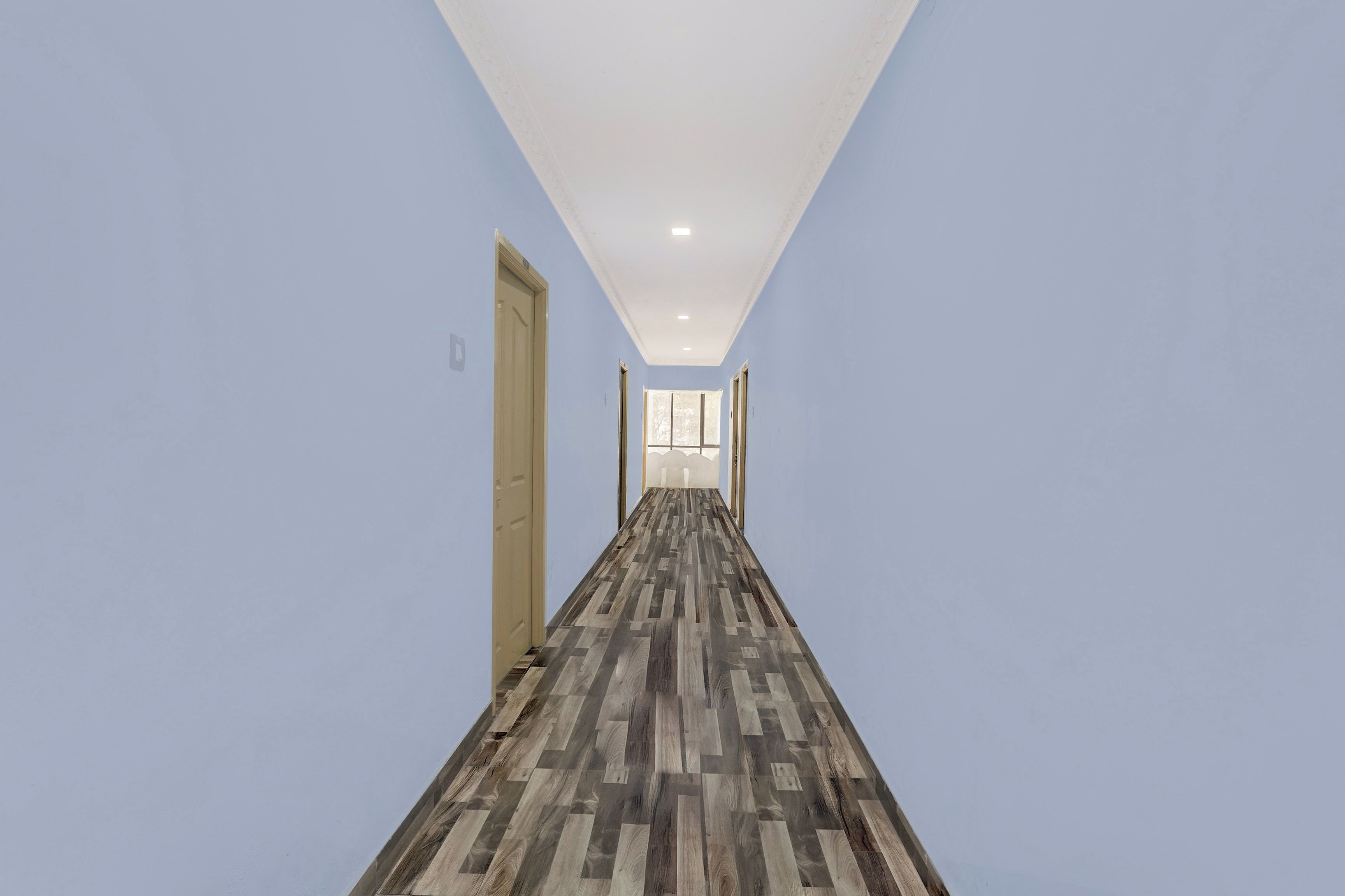 Um corredor com piso estampado, paredes azul claro e portas em ambos os lados.