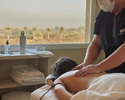 Sessão de massagem em um quarto com vista para uma paisagem árida.