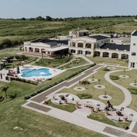 Um hotel espaçoso com piscina, áreas de estar ao ar livre e um jardim bem cuidado.