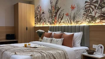 Quarto moderno com cama grande, mesa de cabeceira, guarda-roupa e um mural na parede.