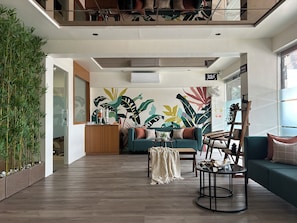 Sala de estar moderna com sofá, mesa de centro e painel decorativo na parede.