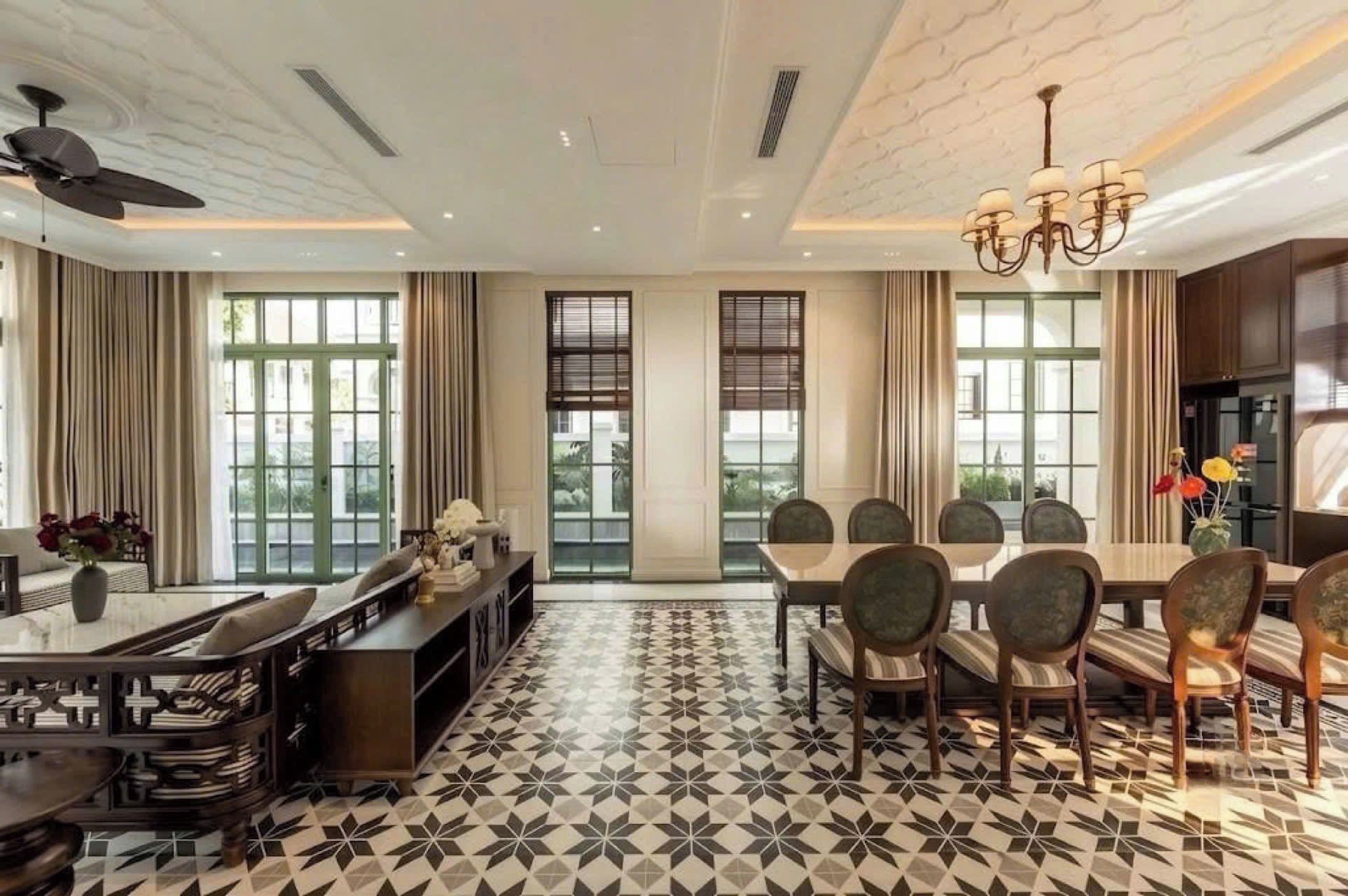 Uma sala de jantar de hotel com uma mesa grande, cadeiras, um sofá e uma televisão.