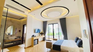 Quarto de hotel moderno com uma cama grande, uma escrivaninha, uma toucador com espelho e vista para o exterior.