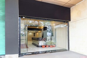 Uma área de recepção moderna com balcão, plantas em vasos e vista para o interior.