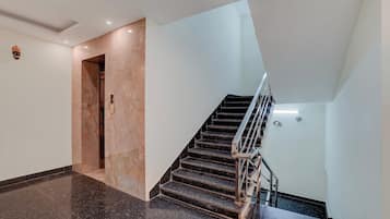 Interior moderno com parede de mármore, escada e porta.