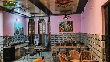 Um restaurante com área de bar, mesas e parede revestida de azulejos.