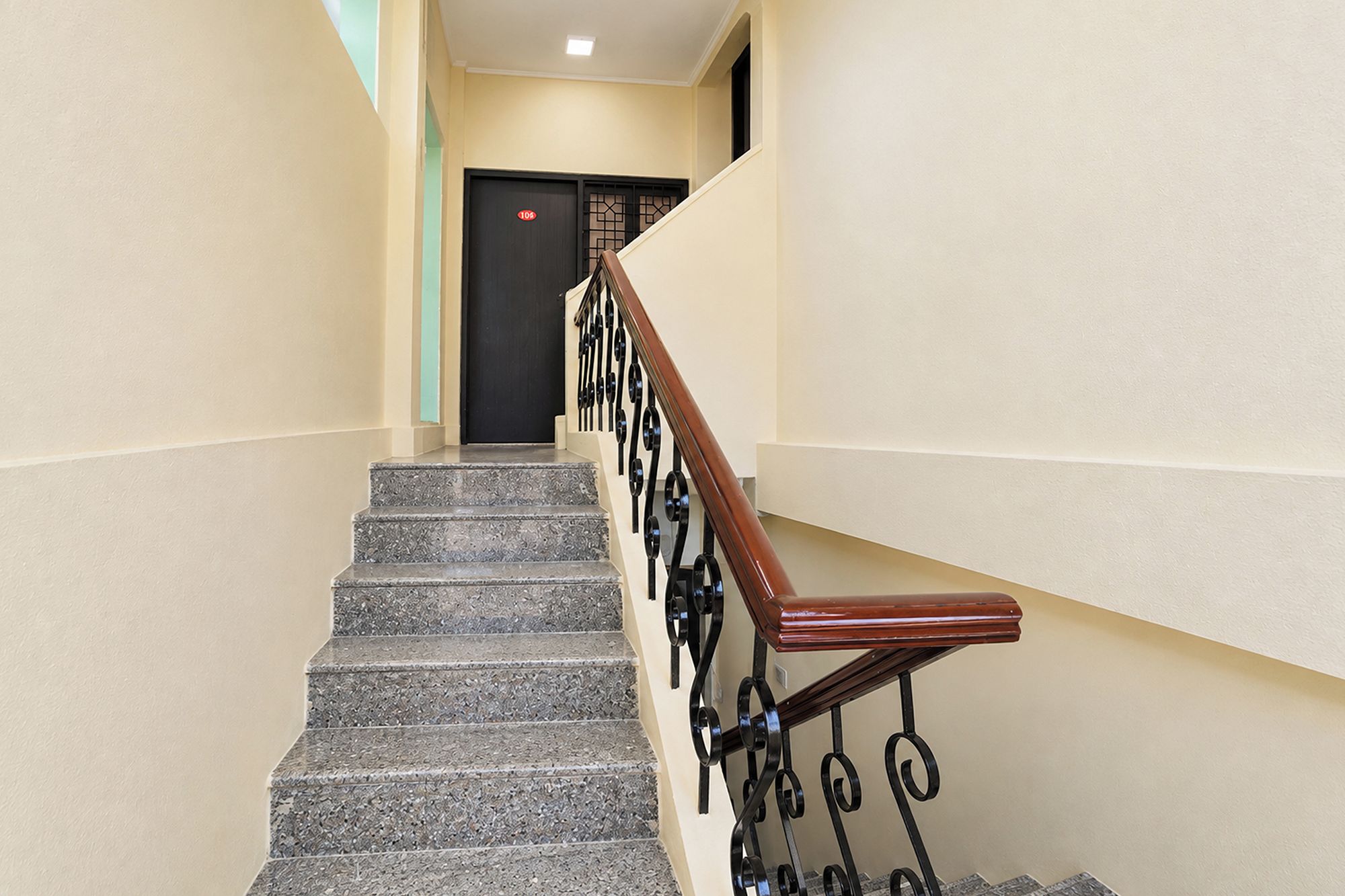 Uma escada com corrimão e uma porta no topo.