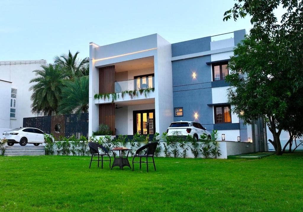 Uma casa moderna de dois andares com varanda, um carro na entrada e um gramado bem cuidado.