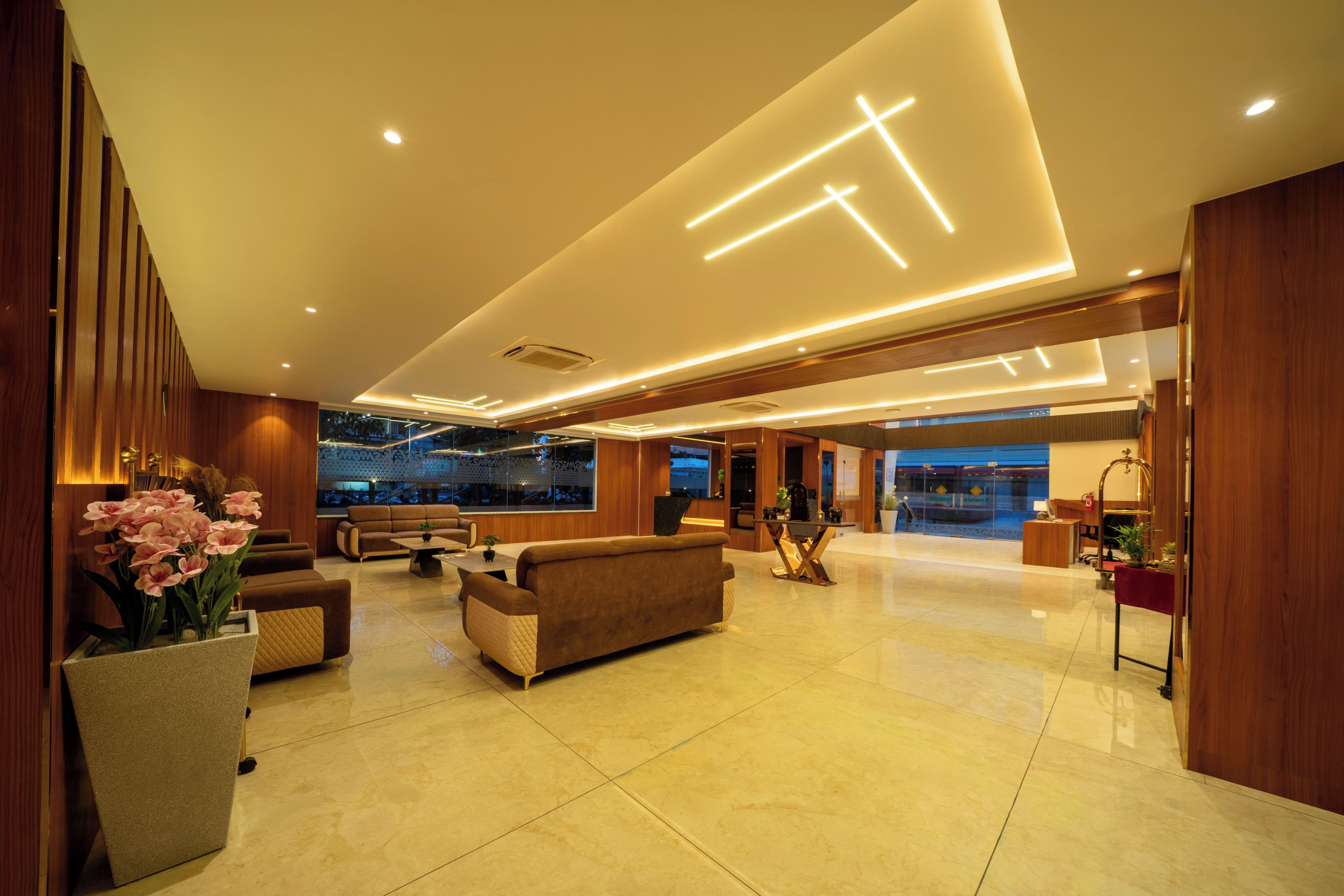 Um hall amplo com design moderno, apresentando uma grande área de estar, balcão de recepção e vista para o exterior.