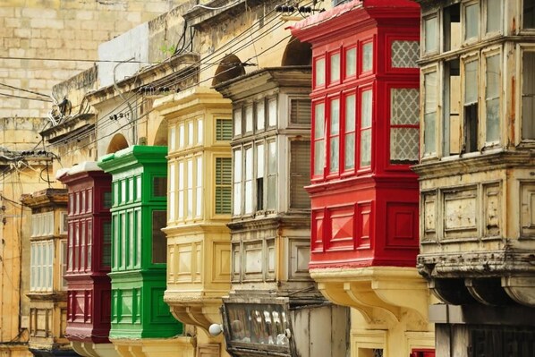 Fileira de edifícios tradicionais com estilos arquitetônicos distintos e molduras de janelas coloridas.